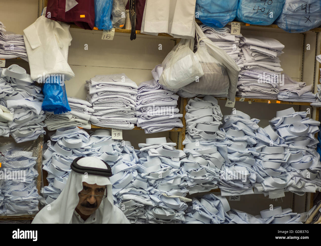 Man selling traditional Arab mens' garments, called thobes, at Souq ...