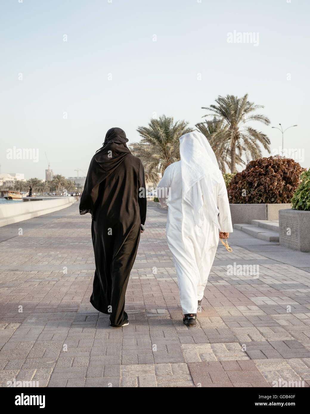 Local couple take a stroll along Doha's corniche Stock Photo - Alamy