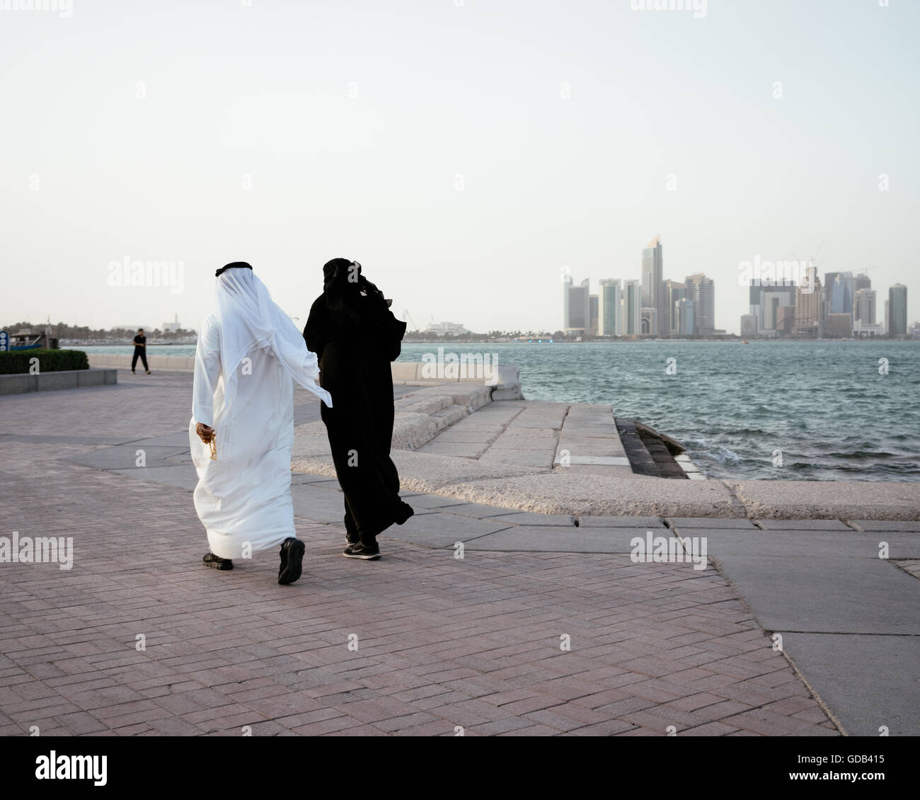 Local couple take a stroll along Doha's corniche Stock Photo - Alamy