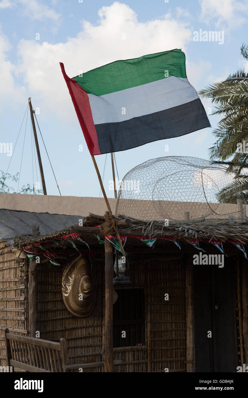 UAE flag above a traditional Emirati house at the Heritage Village ...