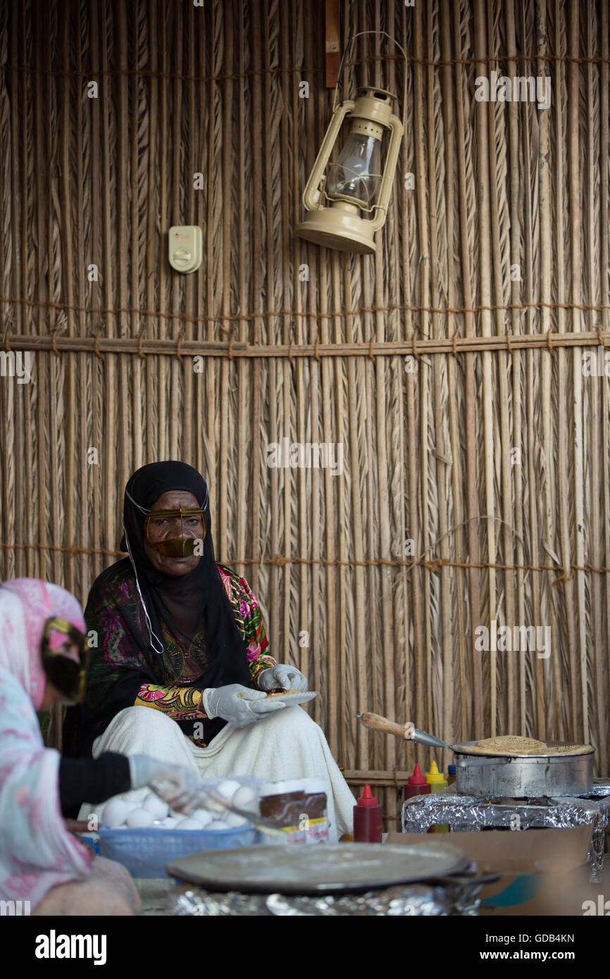 Two Emirati Women wearing traditional dress making Chabab, a ...