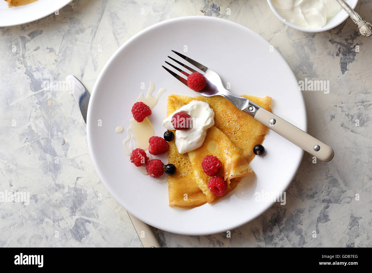golden crepe with raspberry and cream on plate Stock Photo - Alamy
