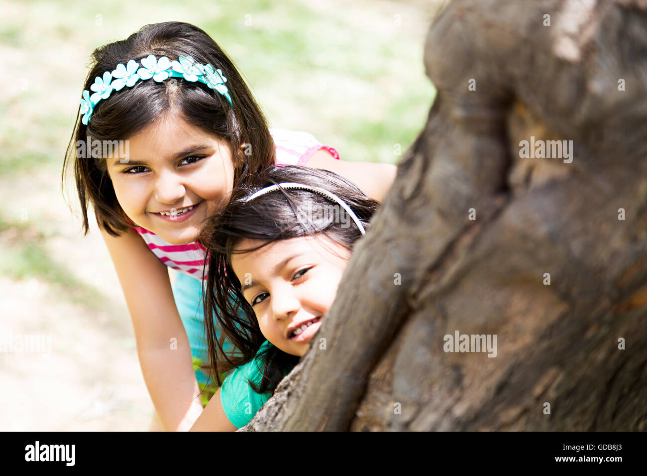 2 indian Kids Girls Only Friends park Tree Trunk standing Hide-and-seek Stock Photo - Alamy