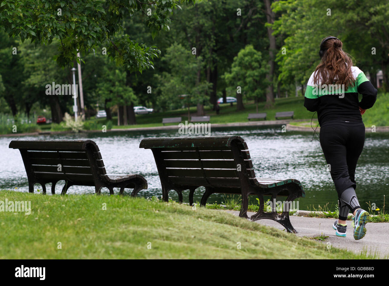 A woman jogging along the water at Parc La Fontaine in Montreal, Que ...
