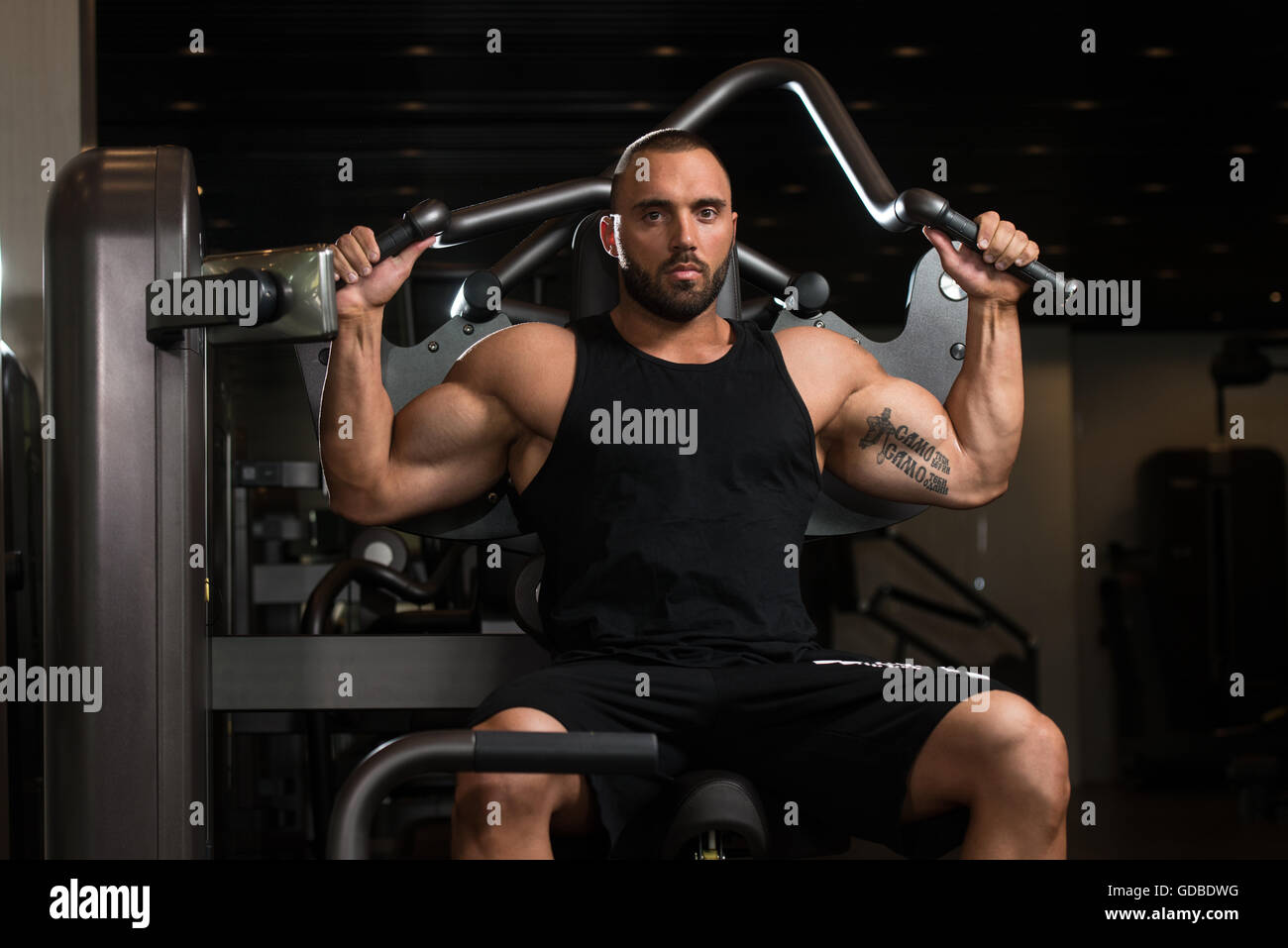 Big Man In The Gym And Exercising Back On Machine - Muscular Athletic ...