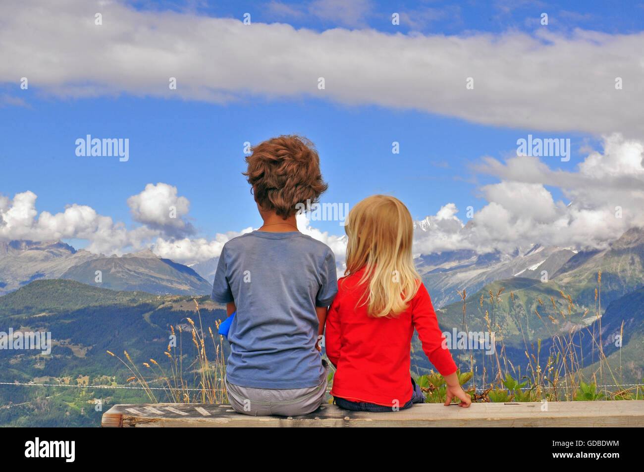 Two kids on the bench in mountains Stock Photo - Alamy