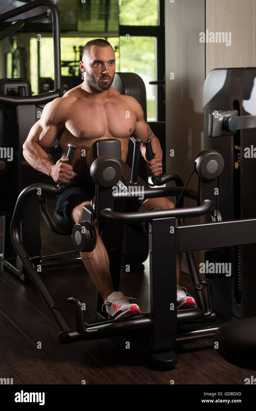 Big Man In The Gym And Exercising Back On Machine - Muscular Athletic ...