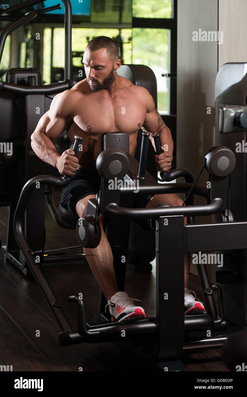 Big Man In The Gym And Exercising Back On Machine - Muscular Athletic ...