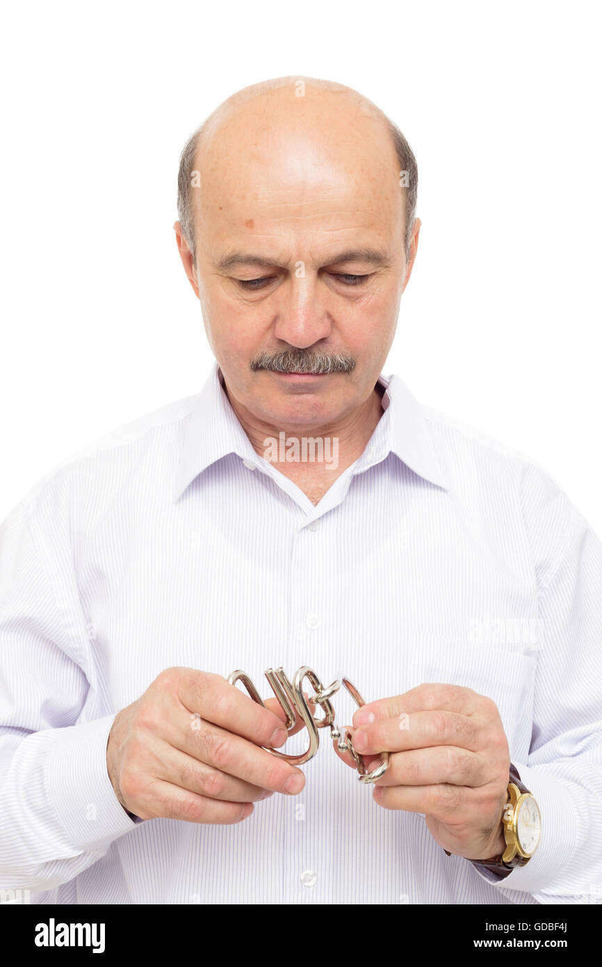 elderly man tries to solve a complex puzzle, jigsaw Stock Photo - Alamy
