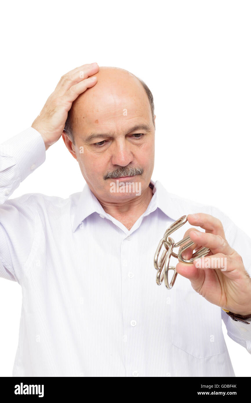 elderly man tries to solve a complex puzzle, jigsaw Stock Photo - Alamy