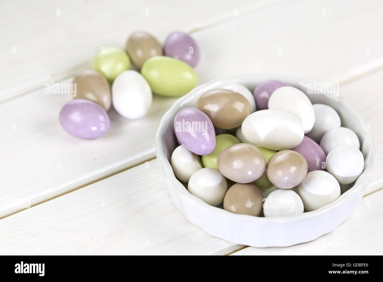 Colorful sugared almonds on wooden white background Stock Photo - Alamy