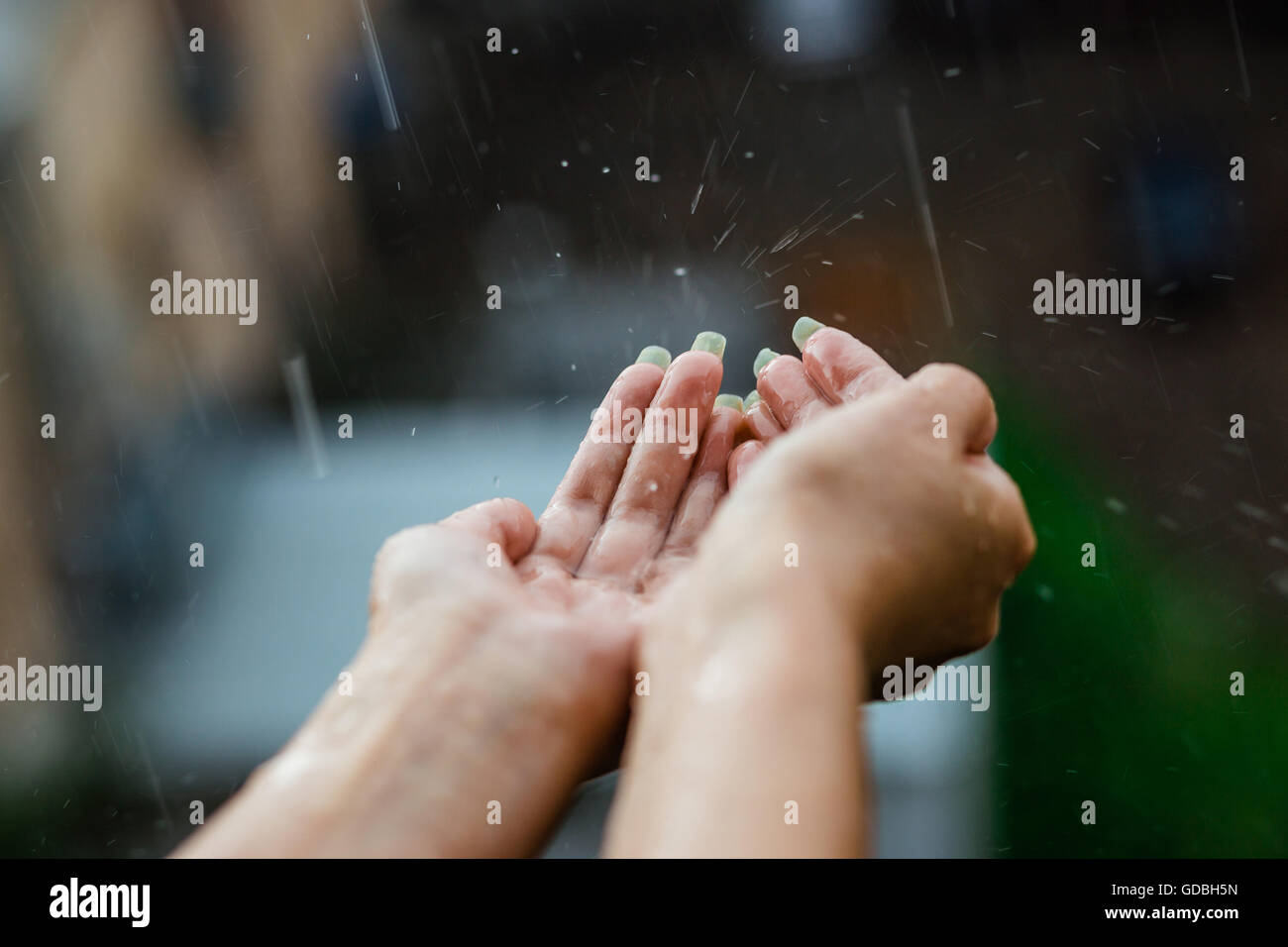 Hands catching clean falling rain water close up. Environmental and ...