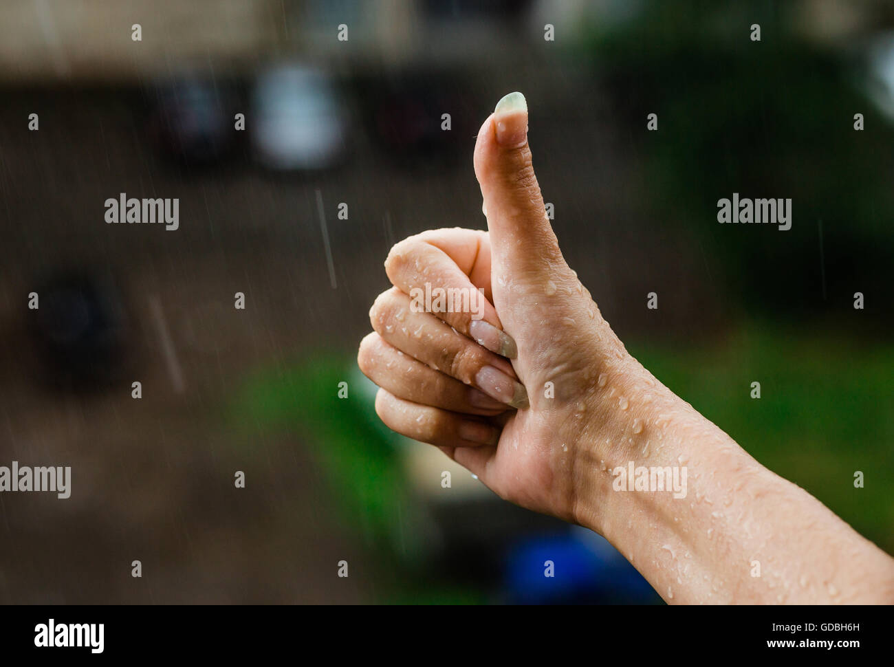 thumbs up sign by wet hands at rain. Environmental and rainy weather ...