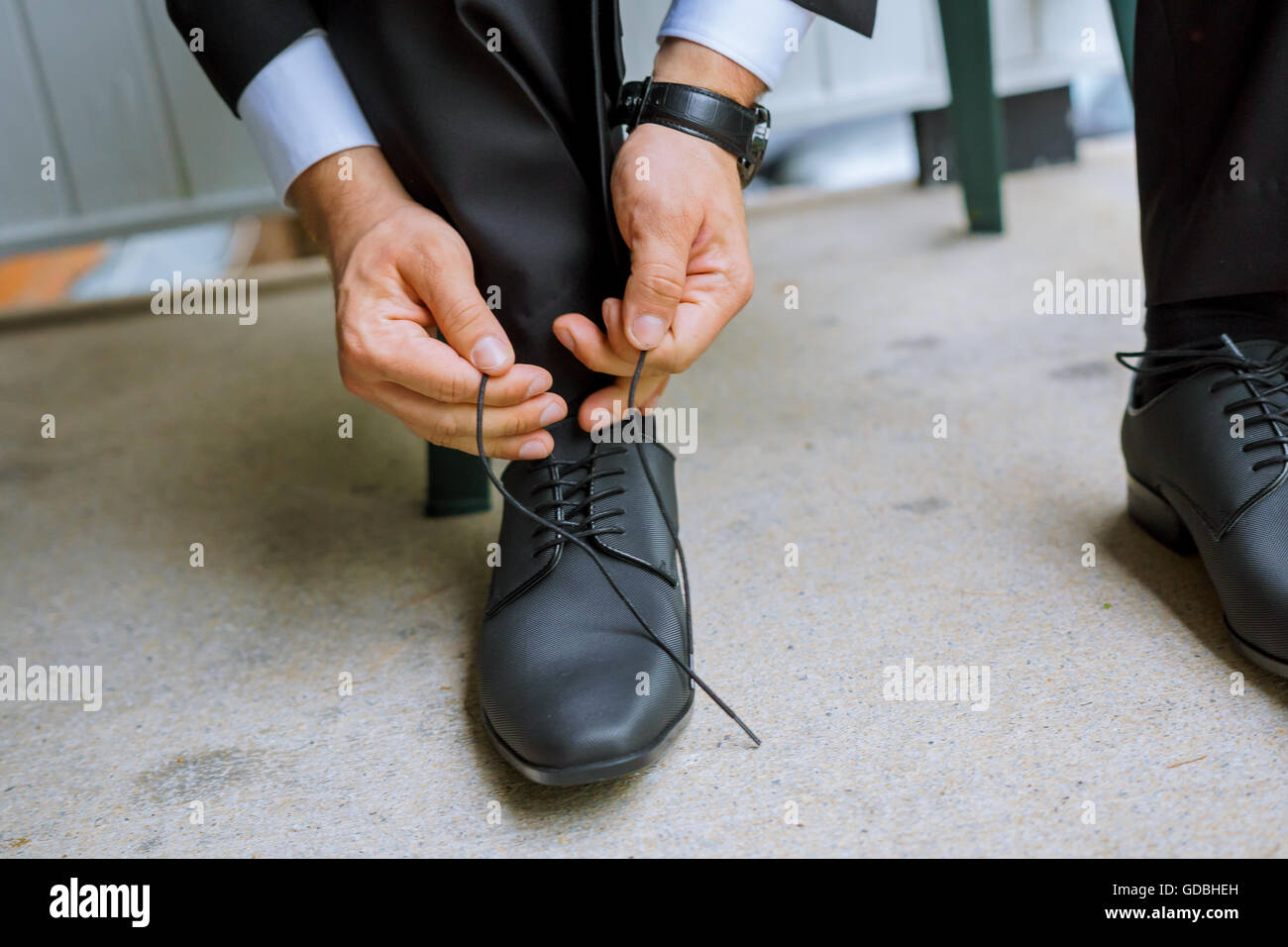 Hands of wedding groom getting ready in suit putting his wedding shoes ...