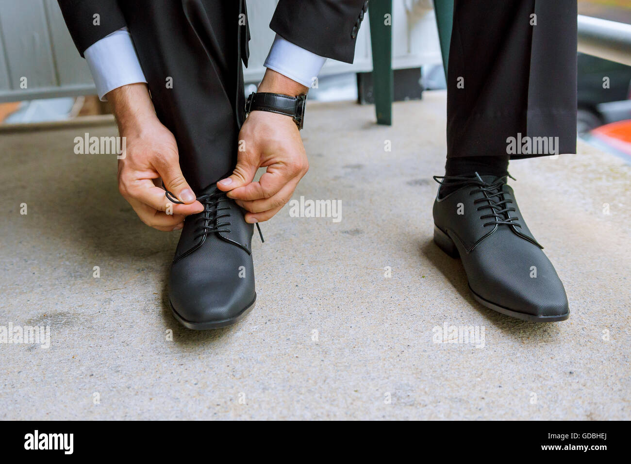 Hands of wedding groom getting ready in suit putting his wedding shoes ...