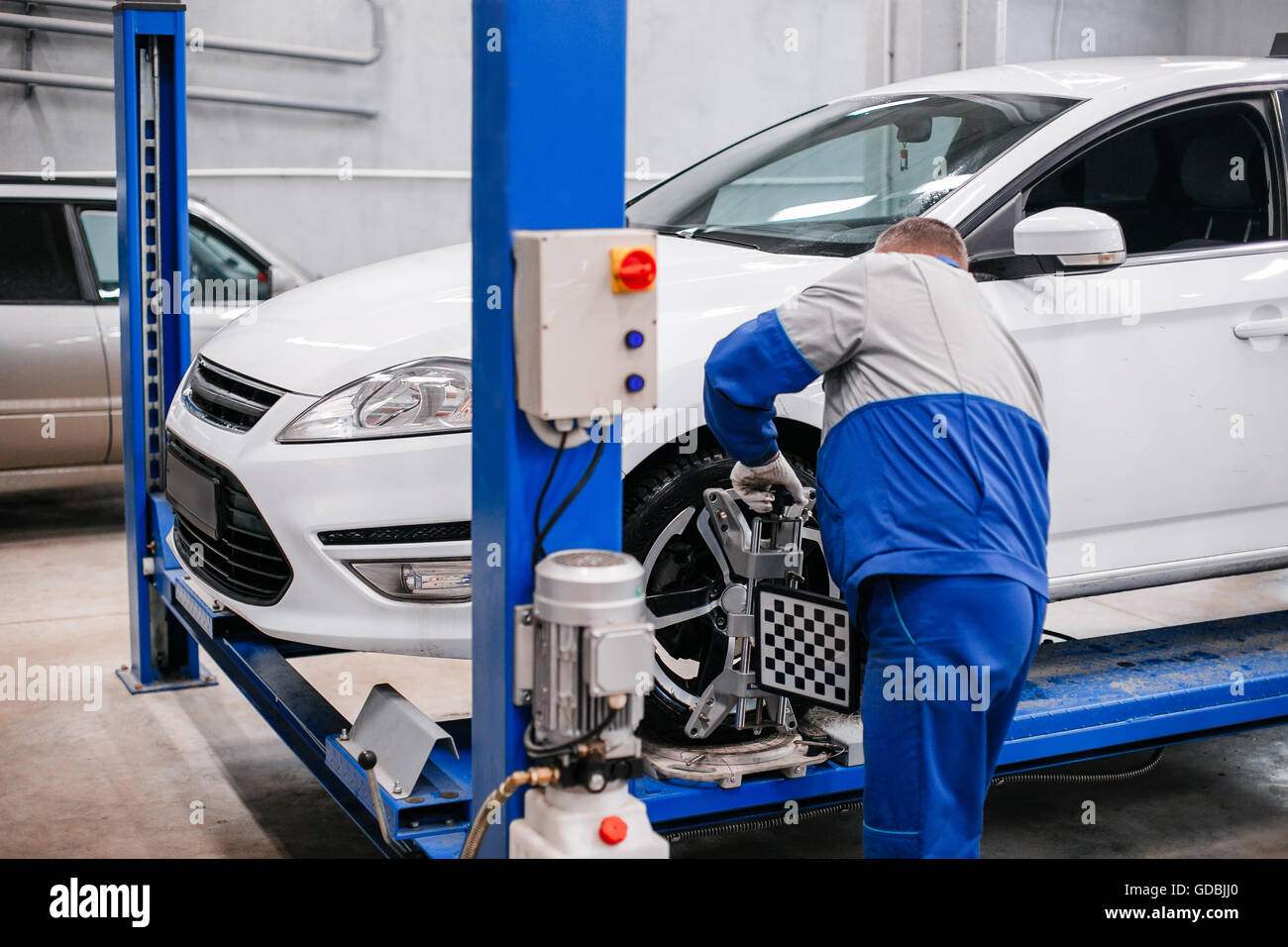 mechanic changing a wheel of a modern car in a workshop Stock Photo - Alamy
