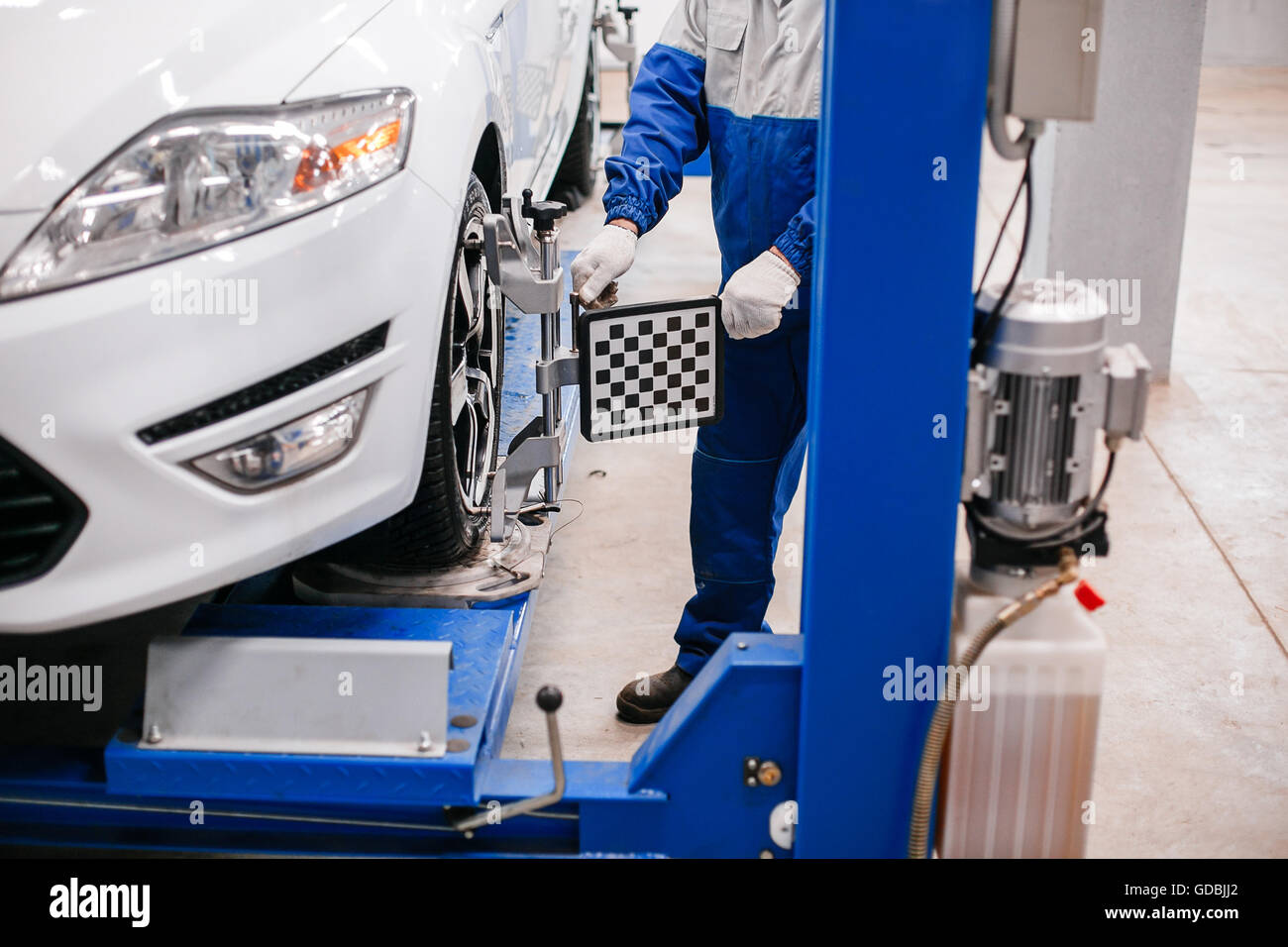 mechanic changing a wheel of a modern car in a workshop Stock Photo - Alamy