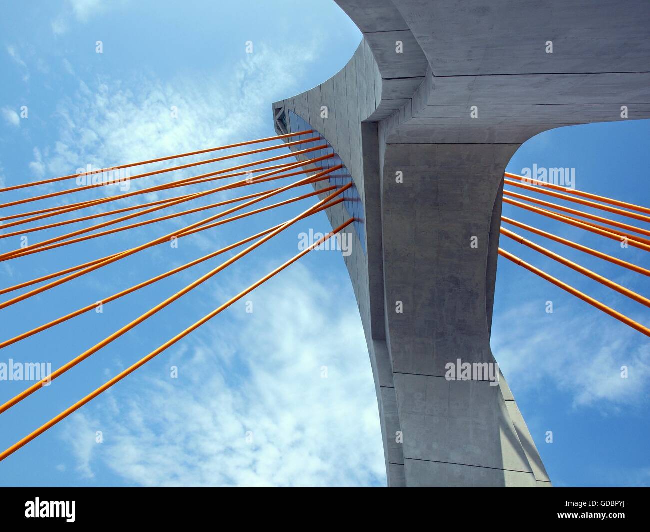 The single tower of a cable stayed bridge with orange steel cables ...