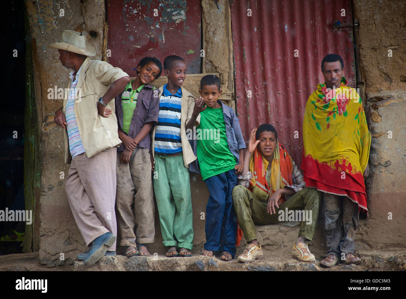 Ethiopian villagers sheltering from the rain outside their colourful ...