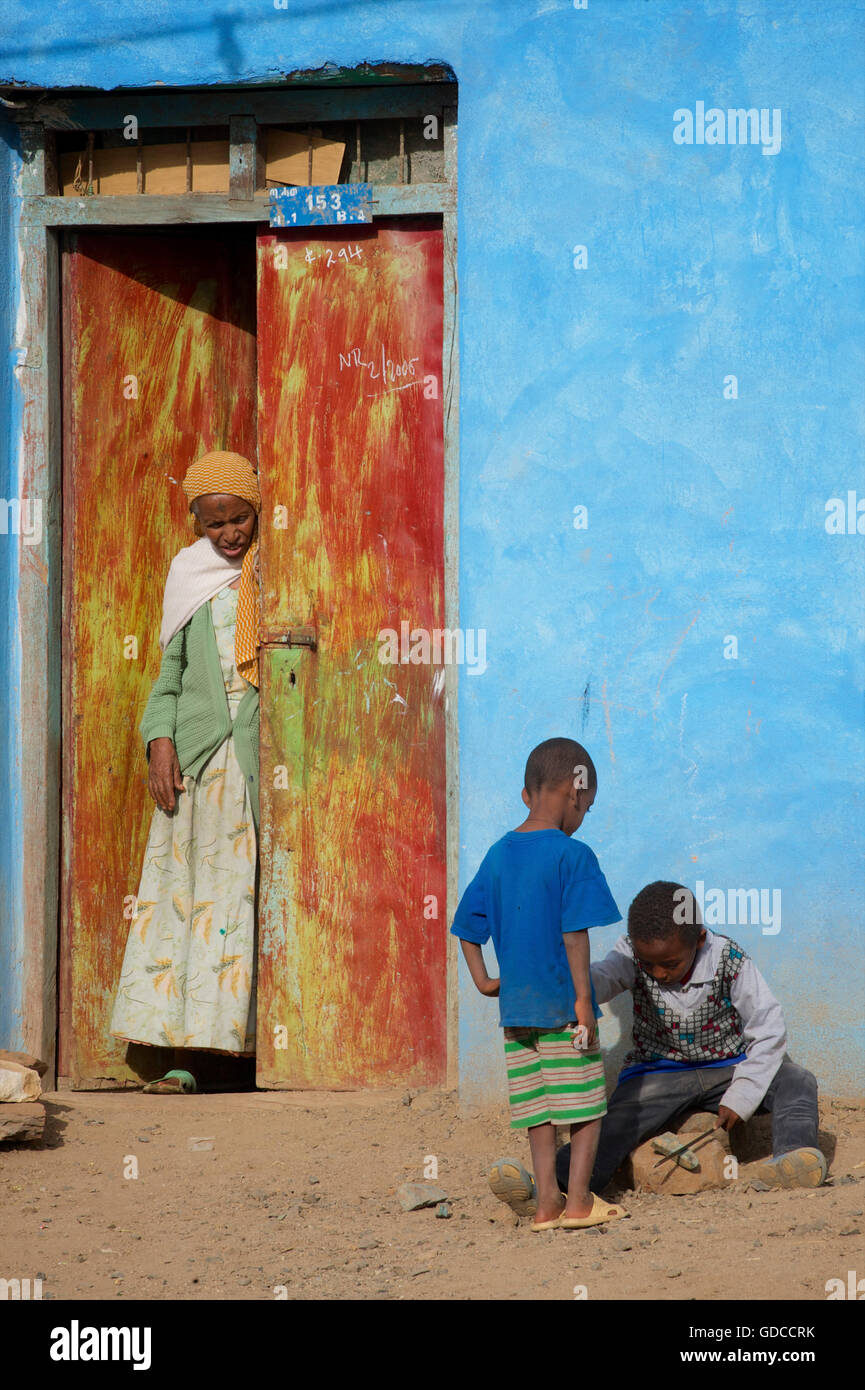 Ethiopian boys trying to move a rock from outside their home, Aksum ...