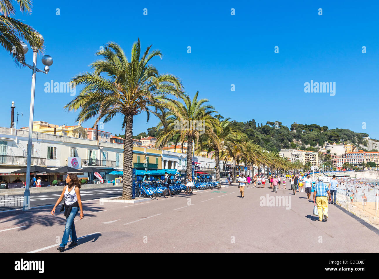 People walk on Promenade des Anglais in City of Nice, Cote D'azur ...