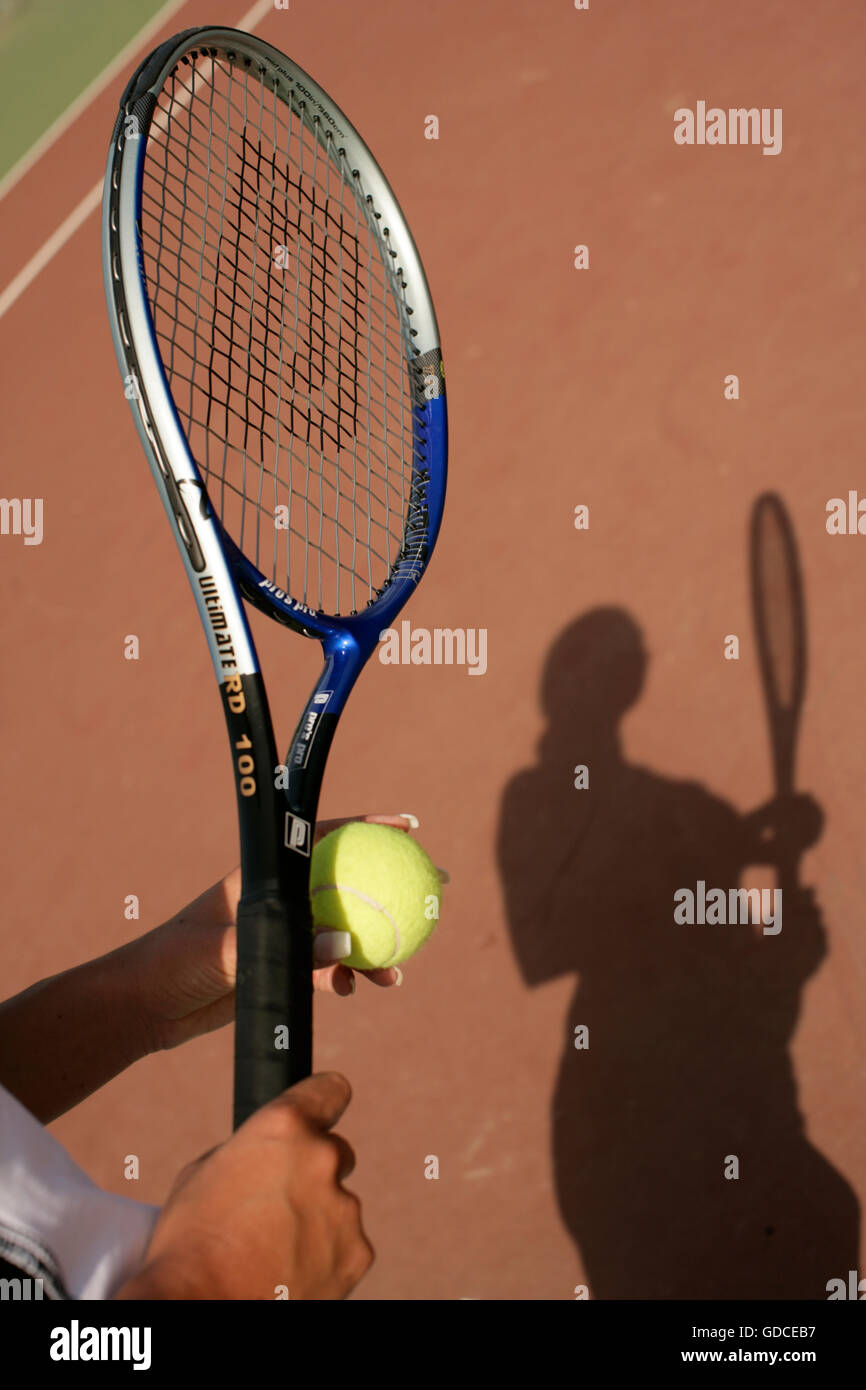 Hand holding tennis racket and ball Stock Photo - Alamy