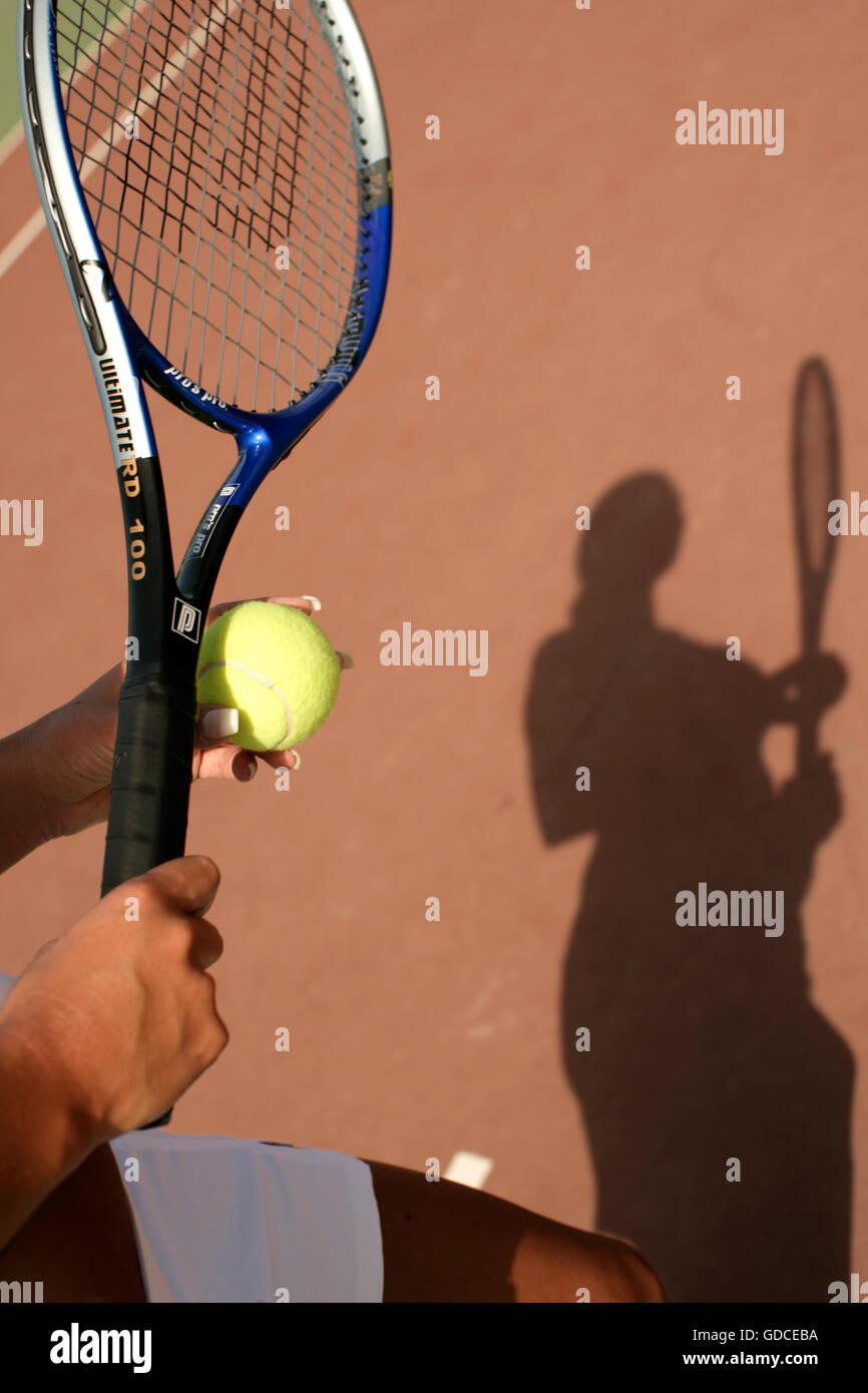 Hand holding tennis racket and ball Stock Photo - Alamy