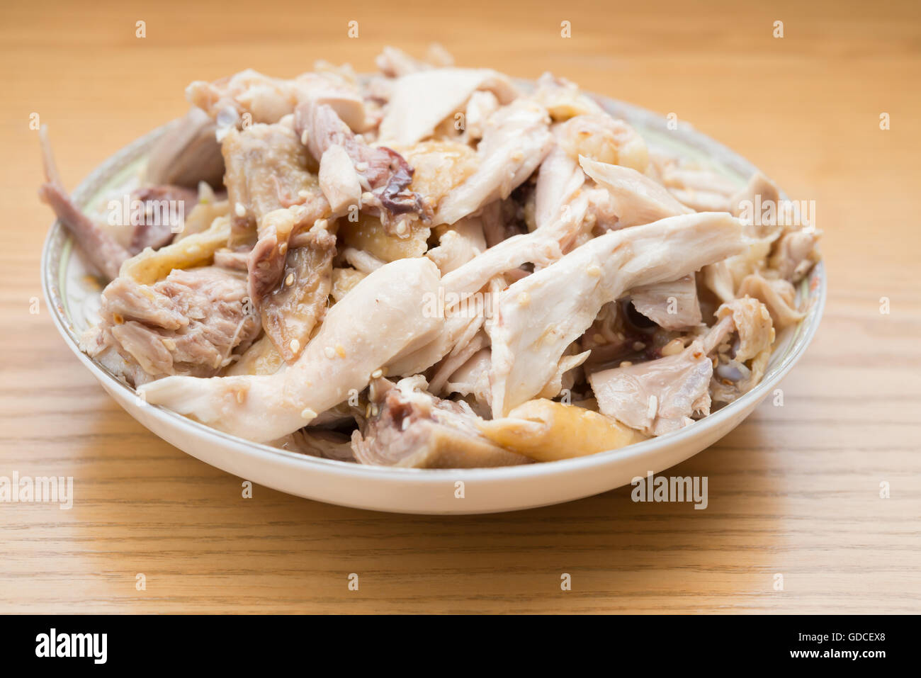 dish of shredded boiled chicken on wood table Stock Photo - Alamy