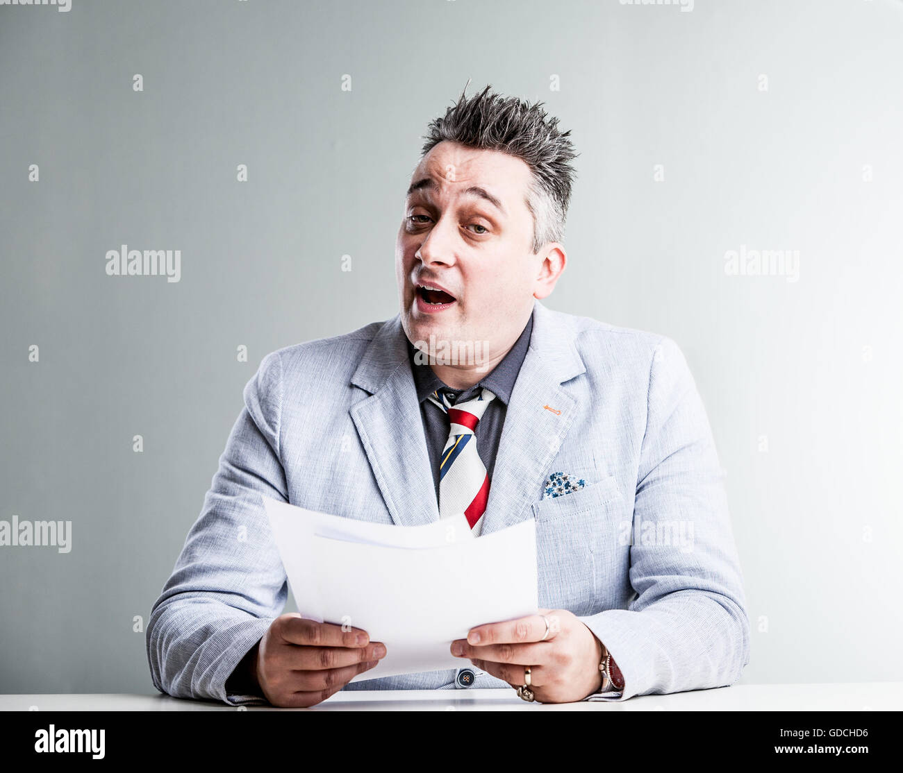stereotypical news anchor talking while holding some sheets Stock Photo ...