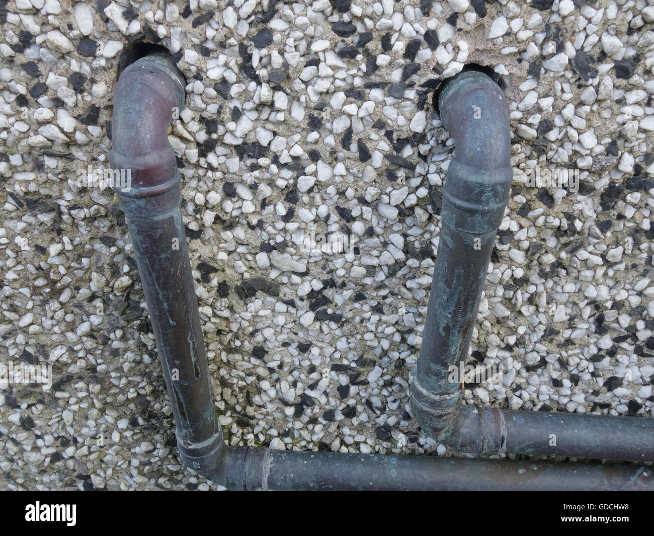 Copper pipes on a pebble dashed wall Stock Photo - Alamy
