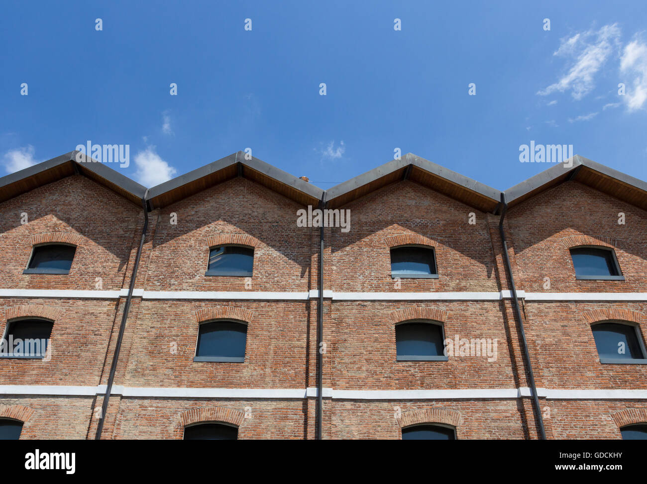 Detail of the facade of a brick row factory against blue sky Stock ...
