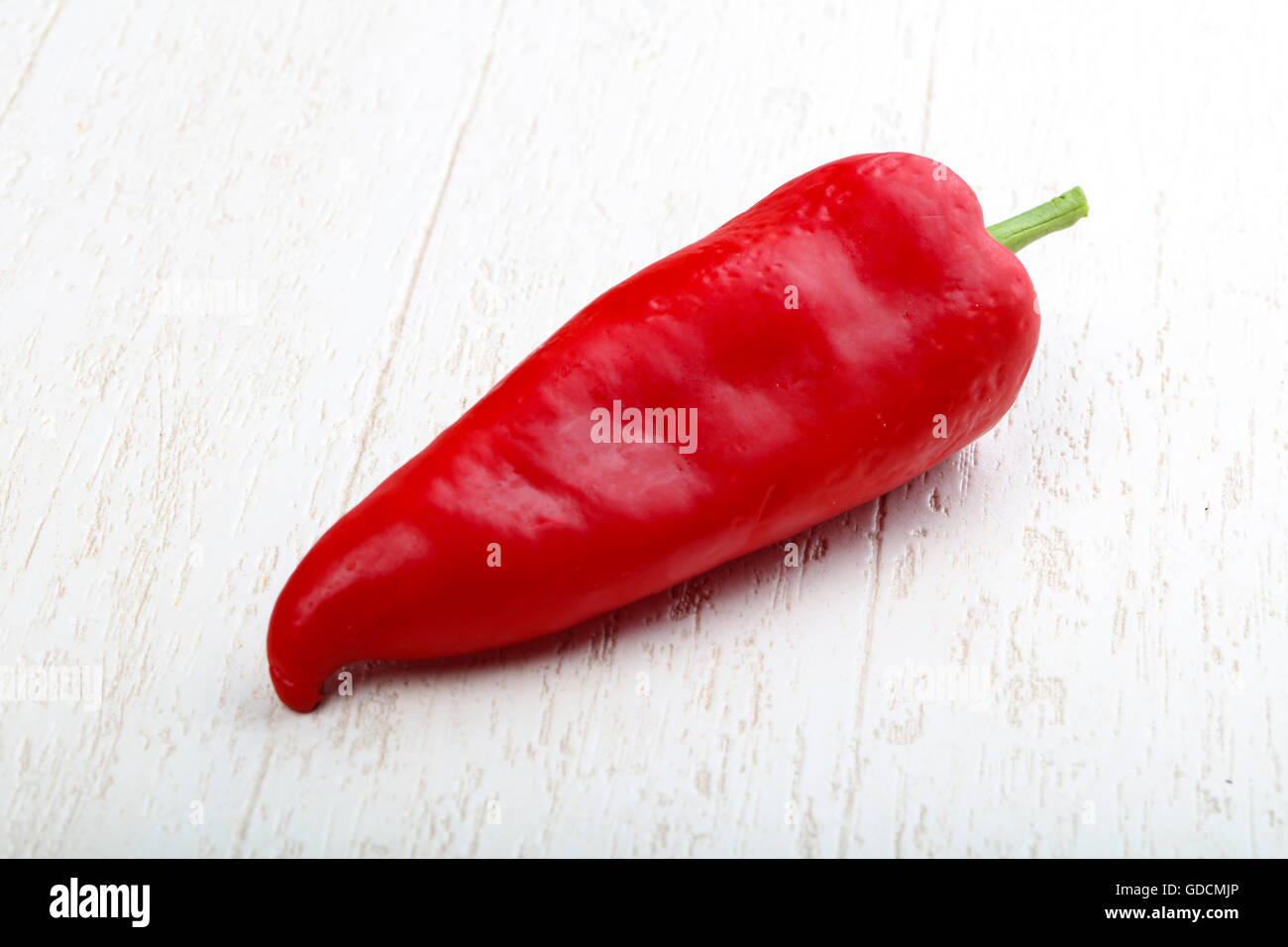Red romano pepper on the wood background Stock Photo - Alamy