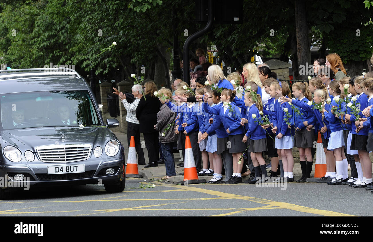 Pupils and staff of Norristhorpe Junior and Infant at School throw white roses at the cortege ...