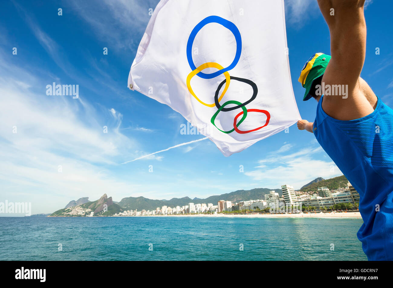 RIO DE JANEIRO - MARCH 27, 2016: Athlete stands flying an Olympic flag ...