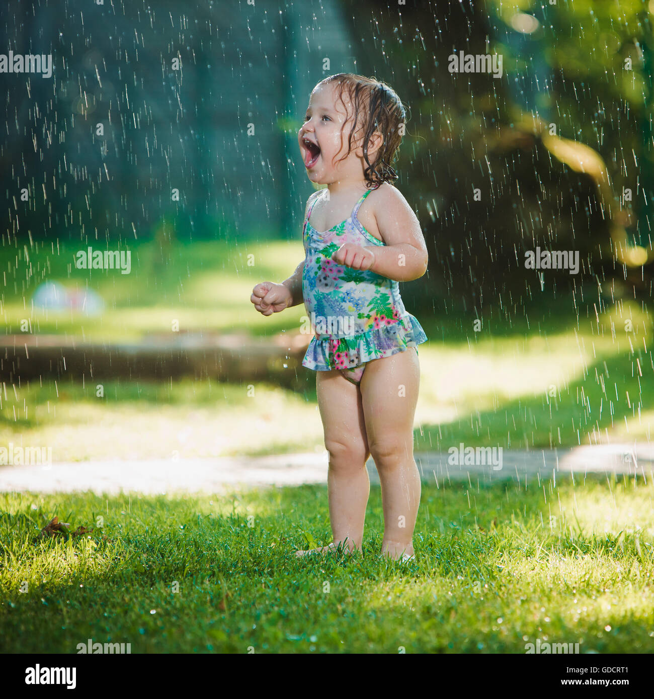 The little baby girl playing with garden sprinkler Stock Photo - Alamy