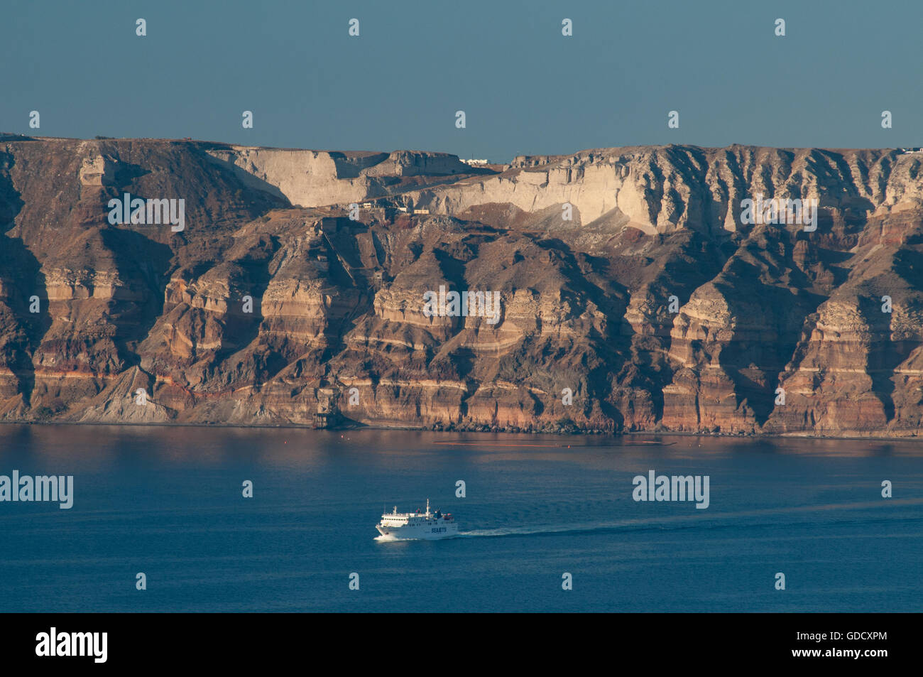Ferry sailing through Caldera volcanic crater, cliffs of Santorini ...