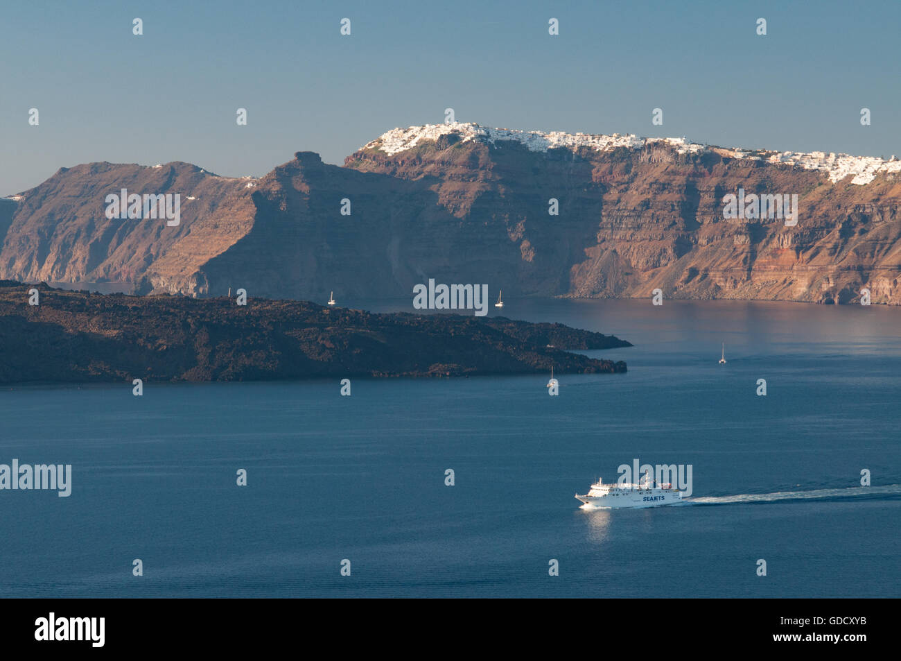 Ferry sailing through Caldera volcanic crater, cliffs of Santorini ...