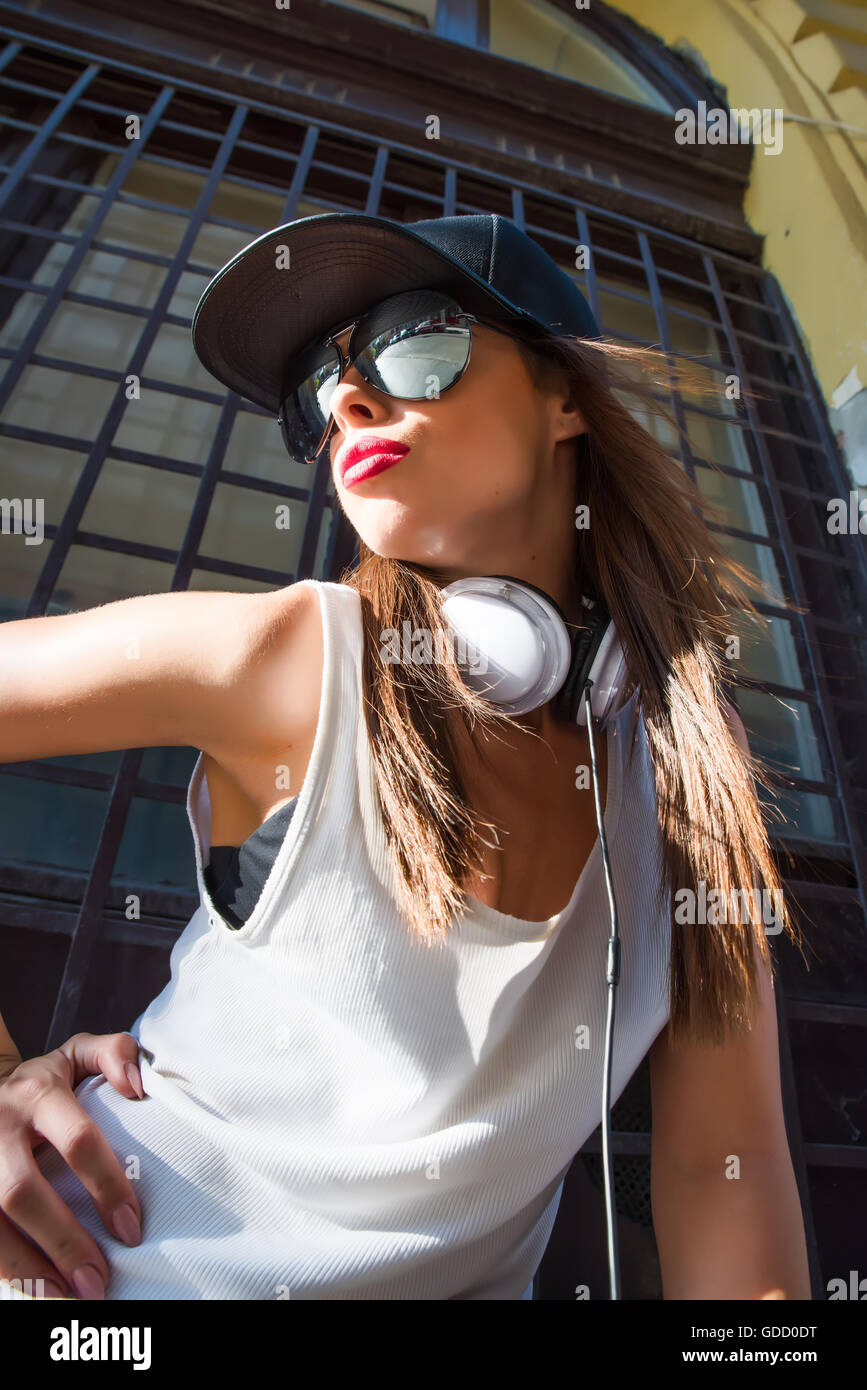 A beautiful Hip Hop Rapper girl with Headphones in a urban environment ...