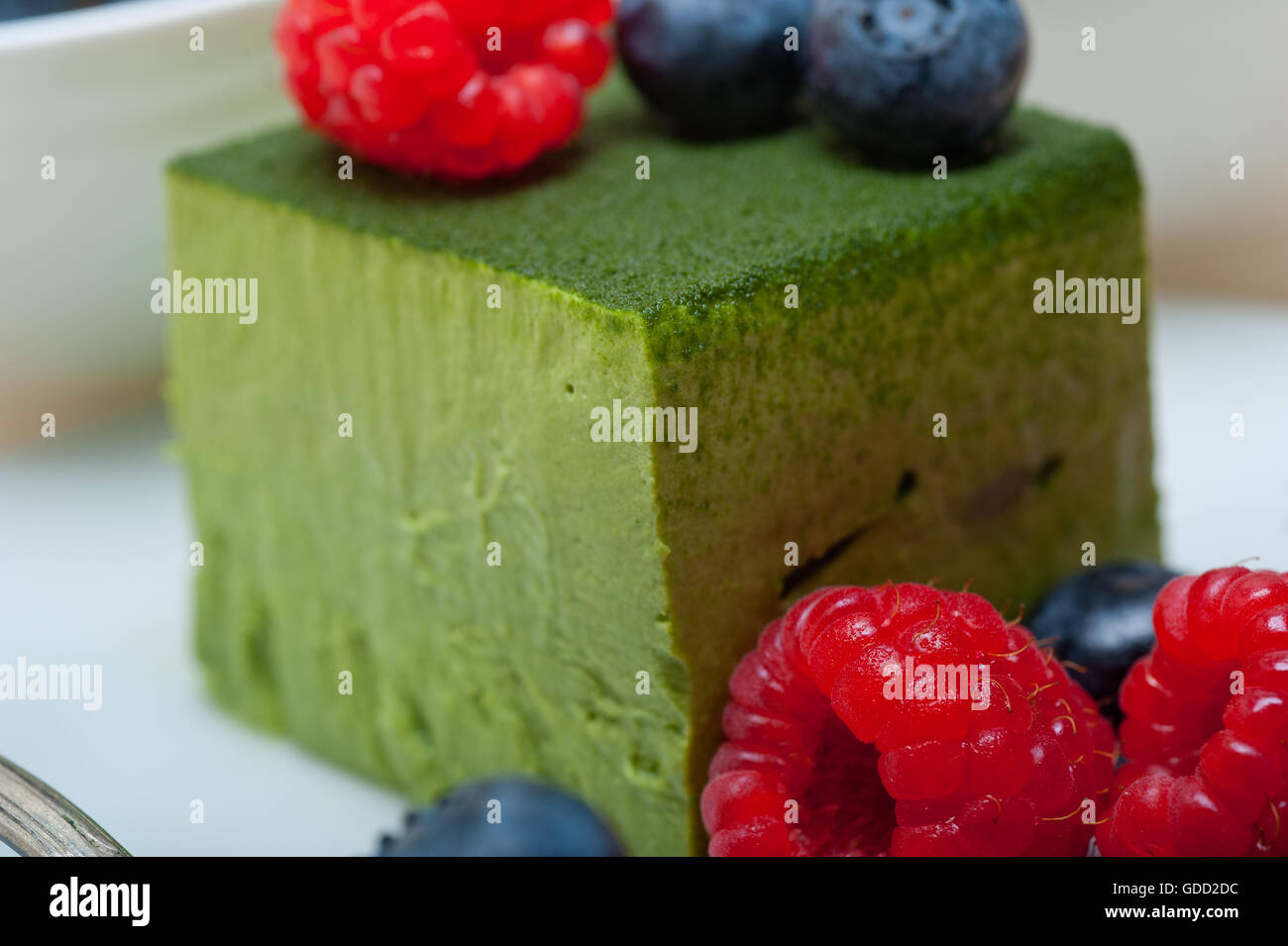 green tea matcha mousse cake with raspberries and blueberries on top ...