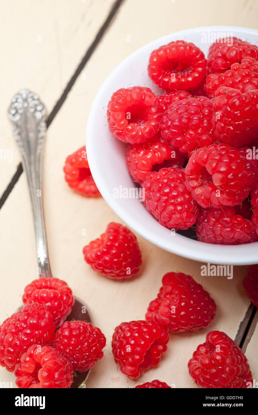 bunch of fresh raspberry on a bowl and white wood rustic table Stock ...