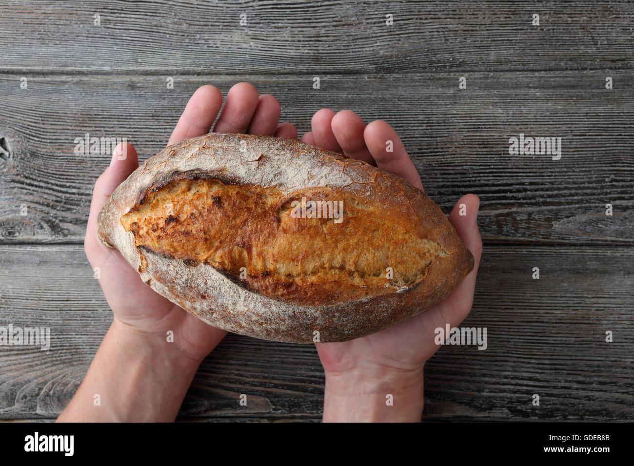 Hands holding loaf bread in hi-res stock photography and images - Alamy