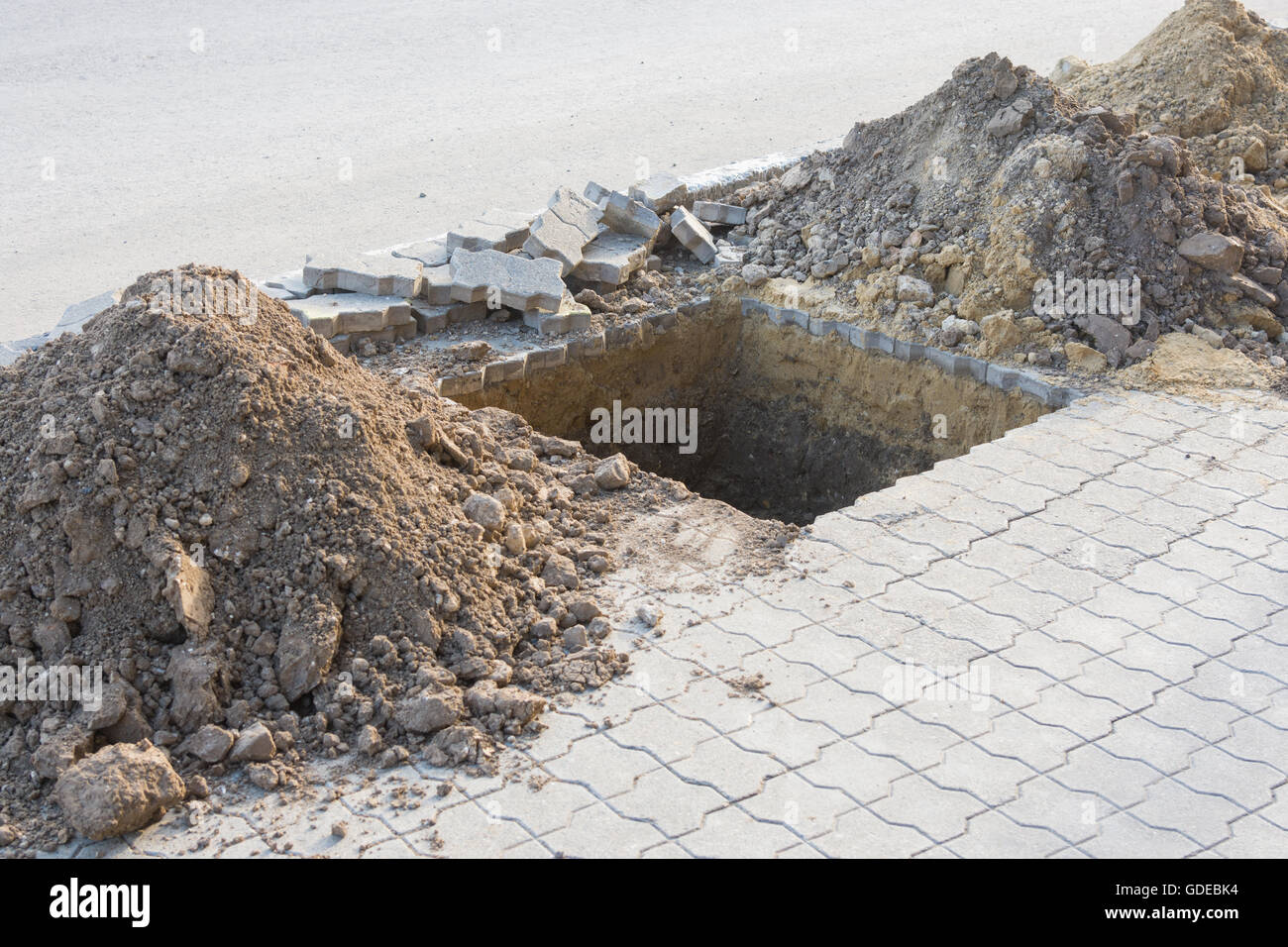 Dug a pit for planting trees on the pavement of paving slabs Stock ...