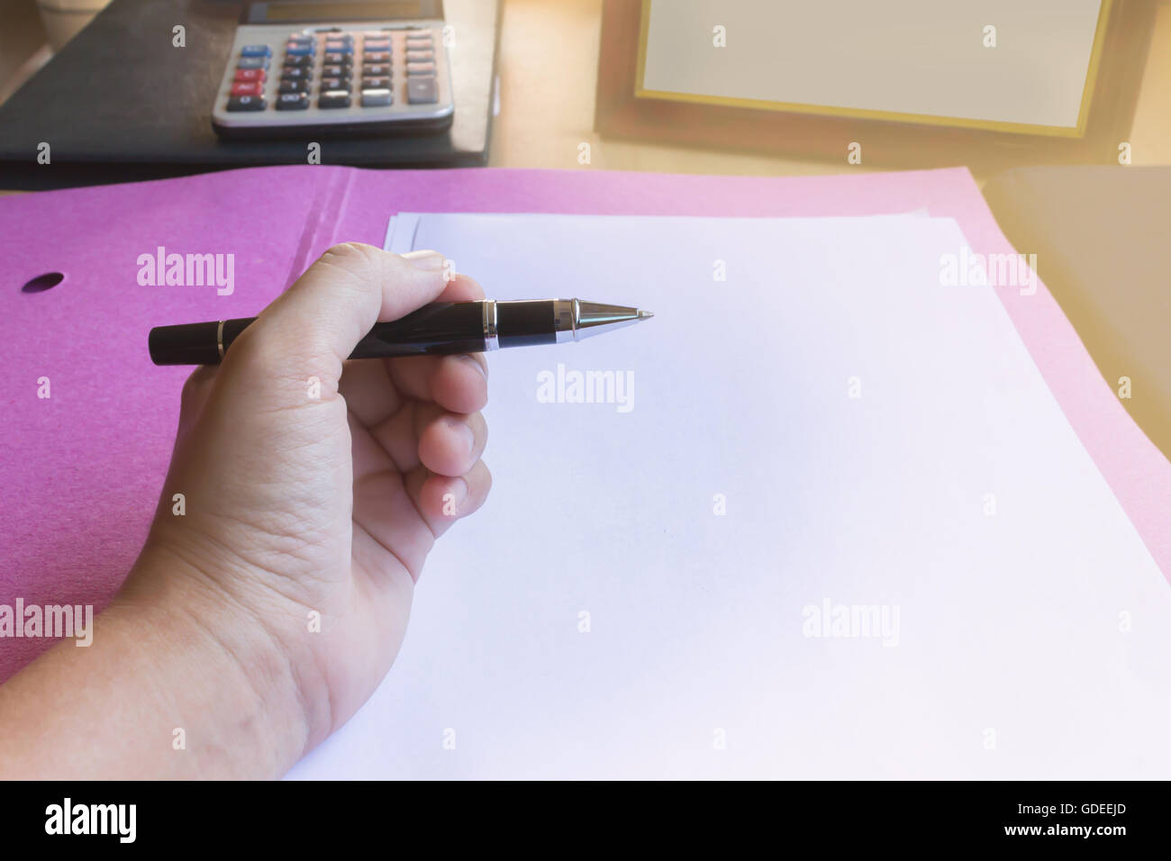 Hand with pen writing down on blank or empty white document paper on ...