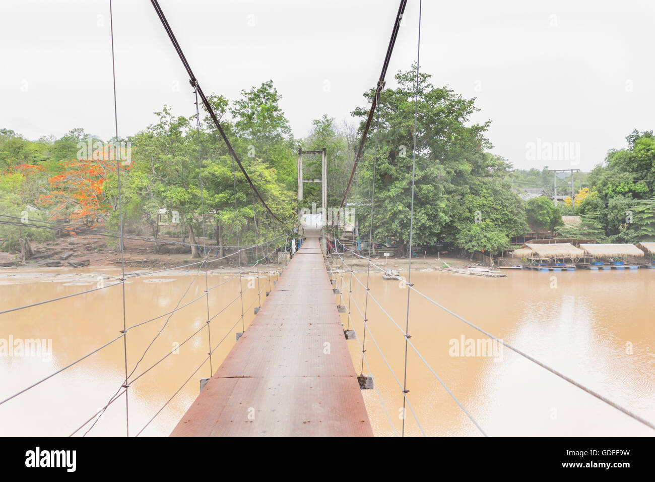 long rope bridge across the river in village at Thailand countryside ...