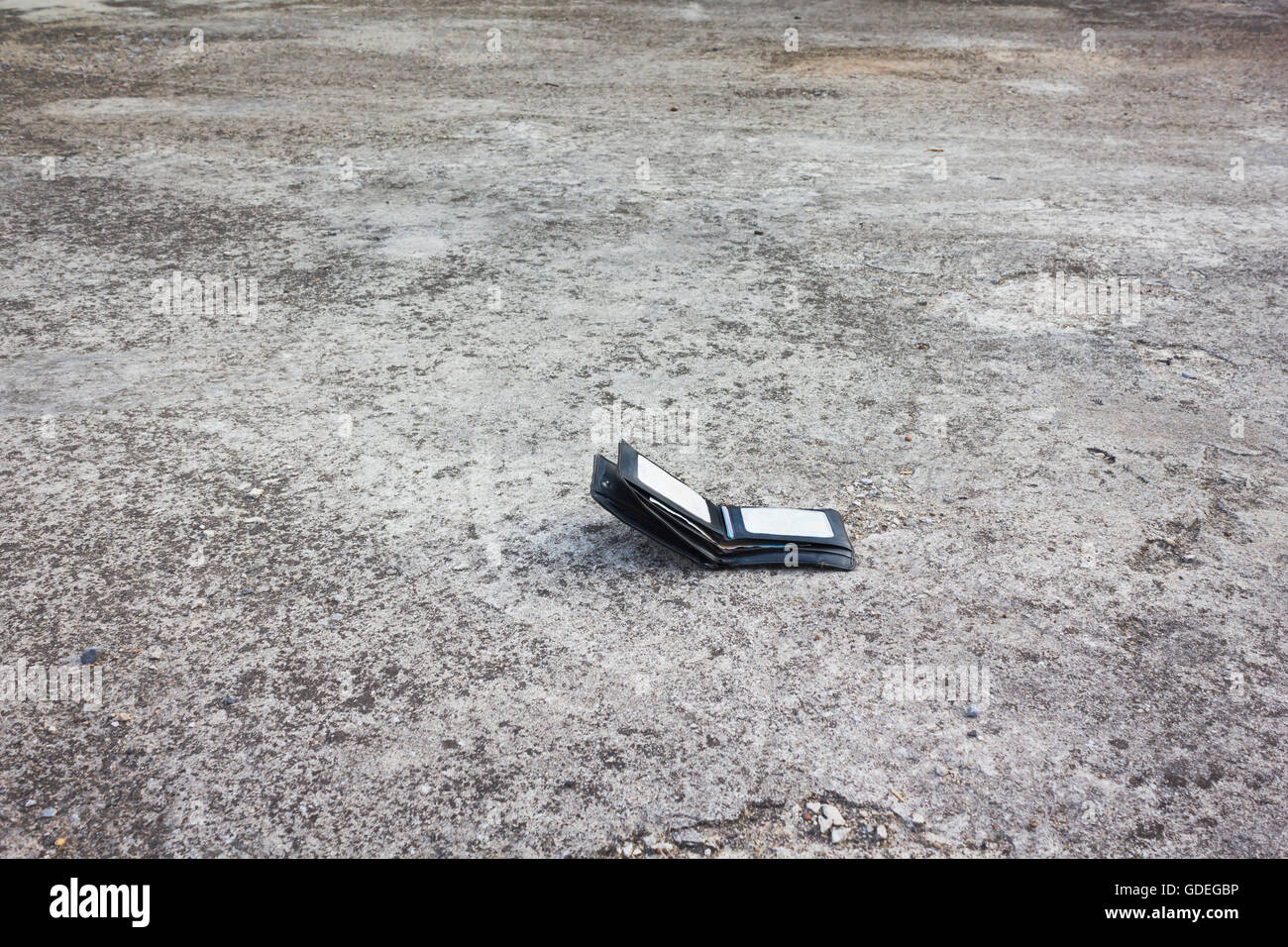 Black wallet drop on the road, missing or lost pocket Stock Photo - Alamy
