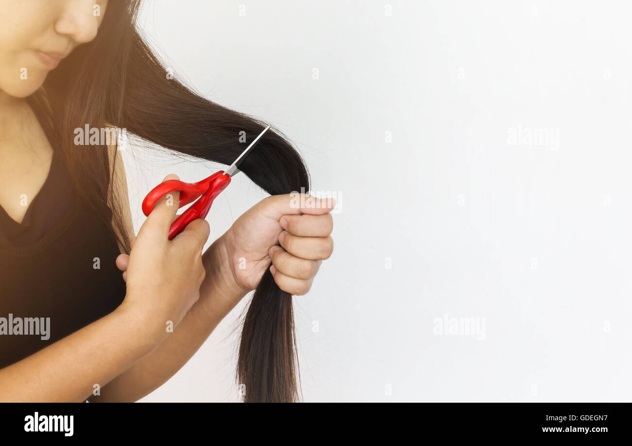 Focused to lady hand catch scissors cutting long hair on plain ...