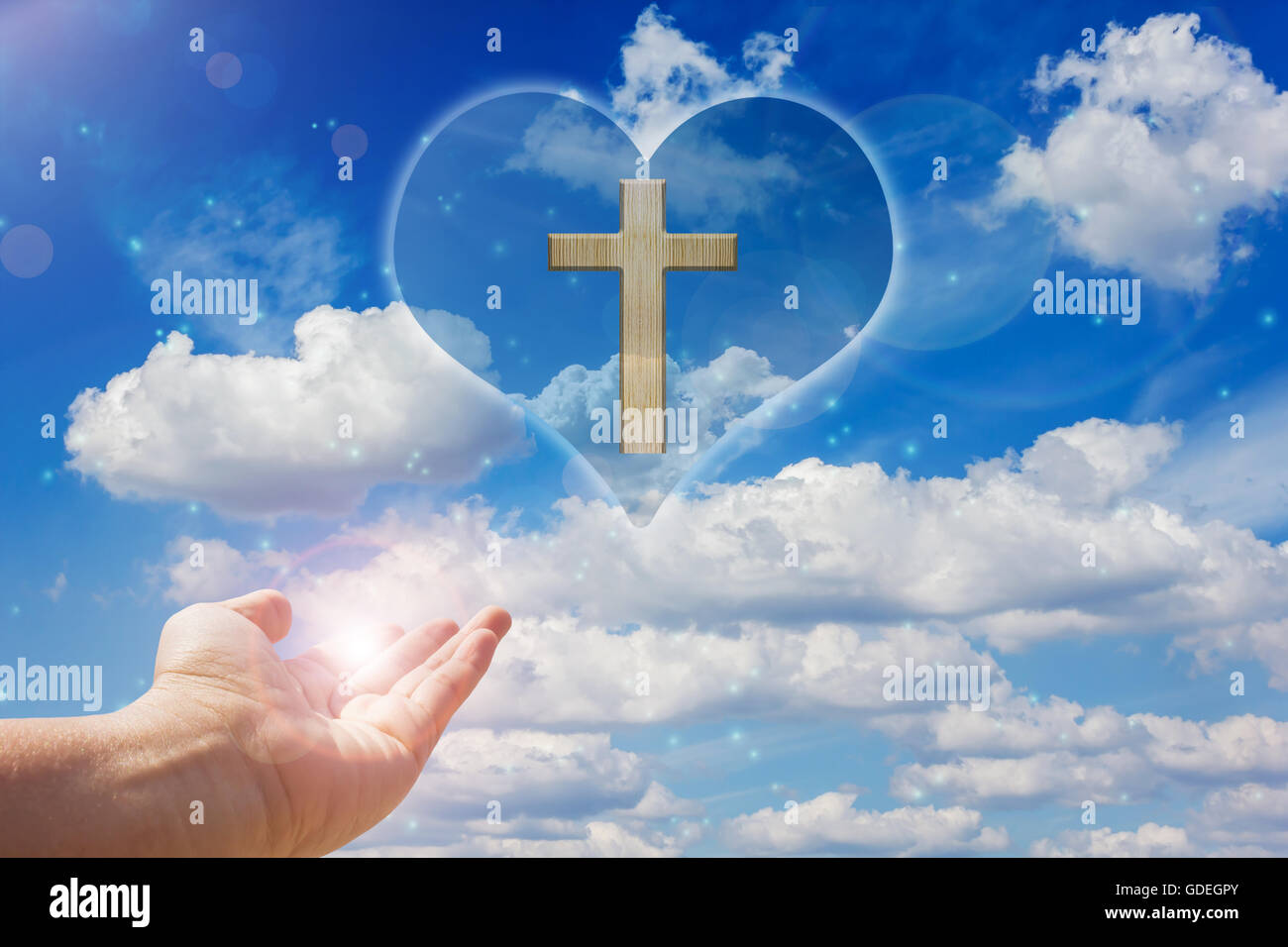 Crucifix and light on heart background with hand Stock Photo - Alamy