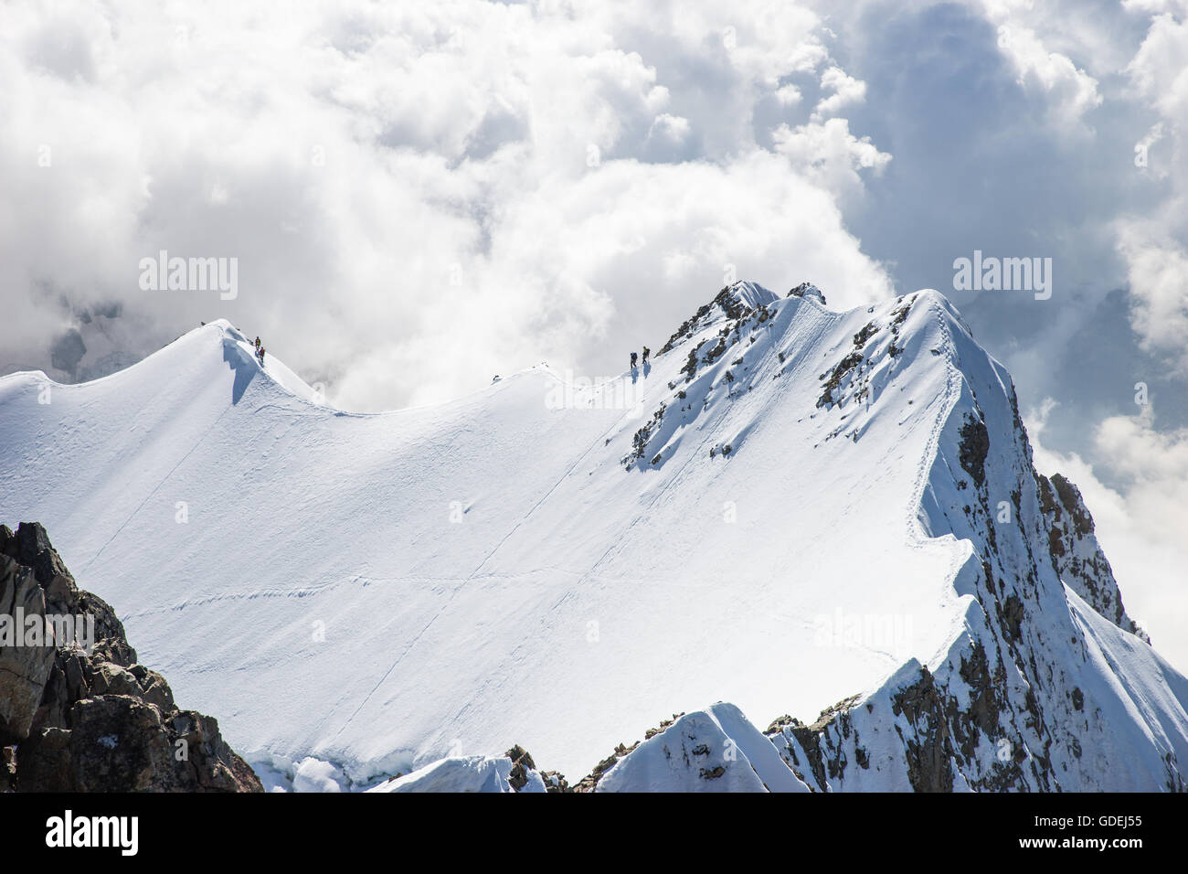 Four people walking along mountain ridge in the swiss alps hi-res stock ...