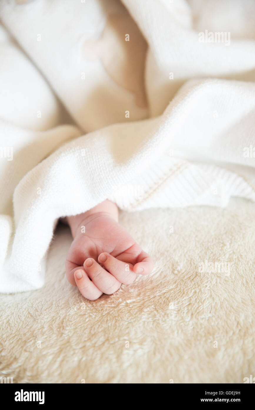 Baby boy's hand sticking out from under a blanket Stock Photo - Alamy