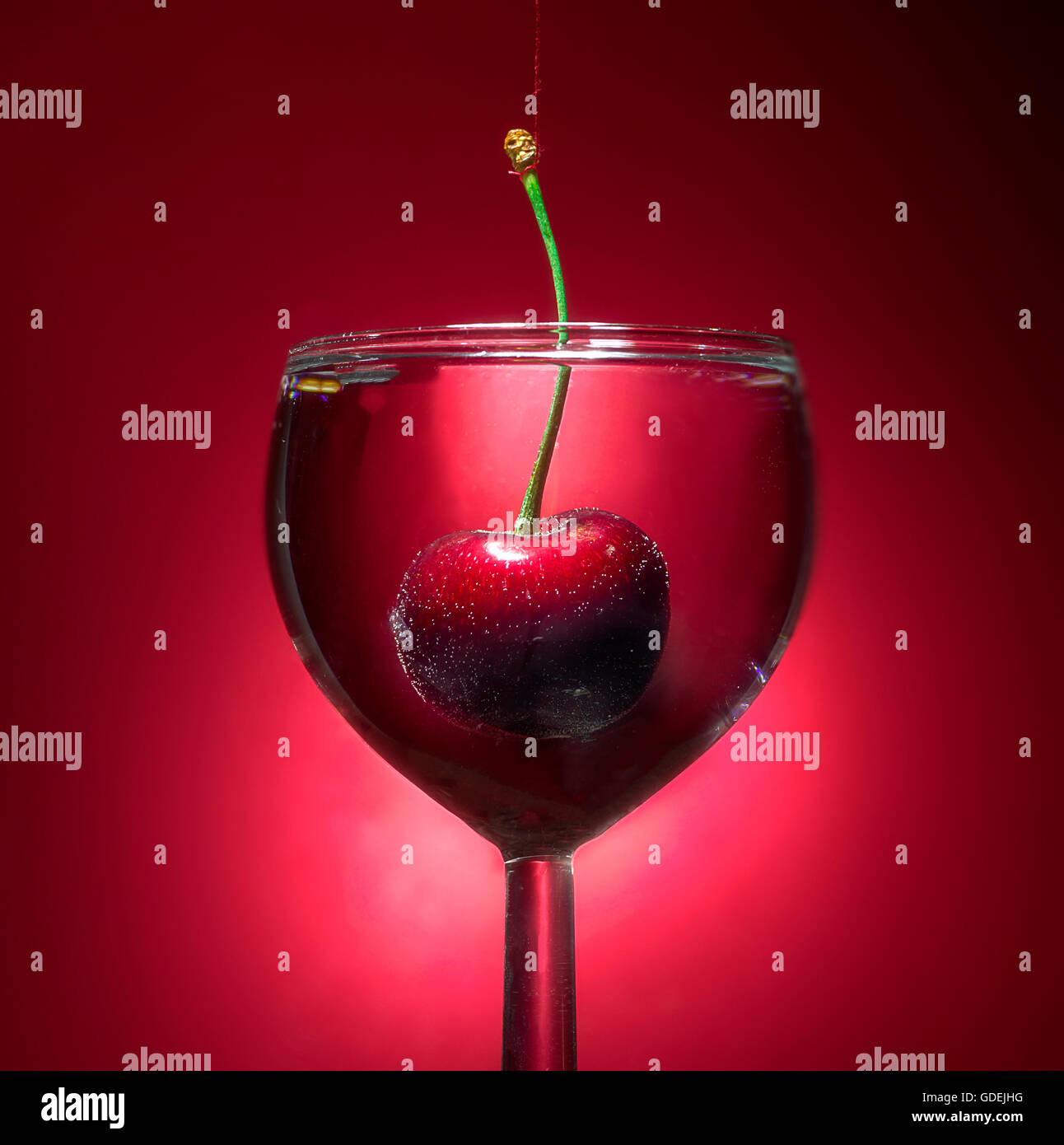Cherry in a glass of water Stock Photo - Alamy